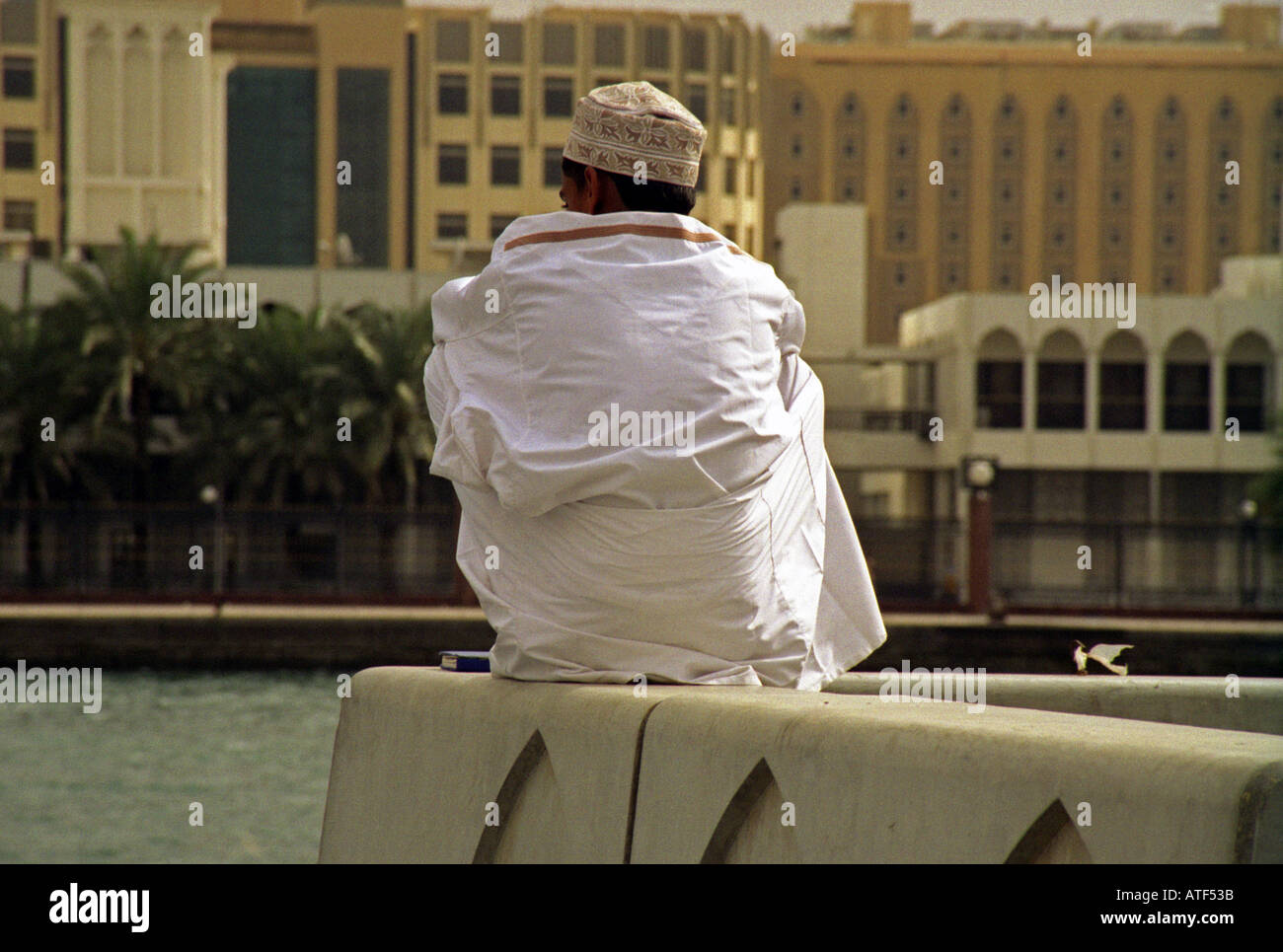Arabic boy in elegant traditional clothing contemplate view by river ...