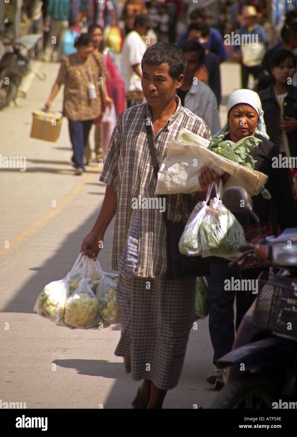 Indigenous peasant man in traditional clothing carry cauliflowers ...