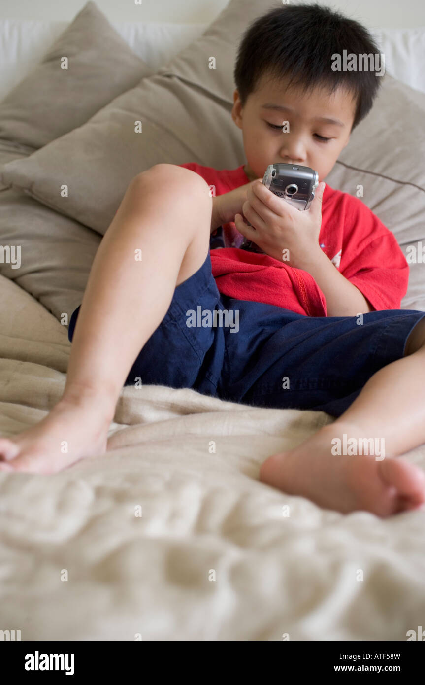Boy playing with cell phone Stock Photo - Alamy