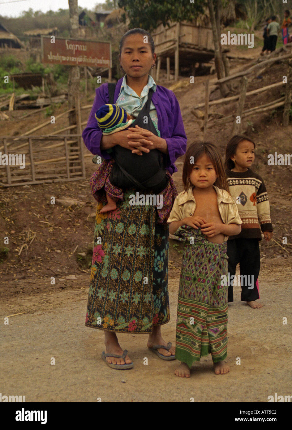 Portrait indigenous woman poor rural village outdoor look baby girl sit ...