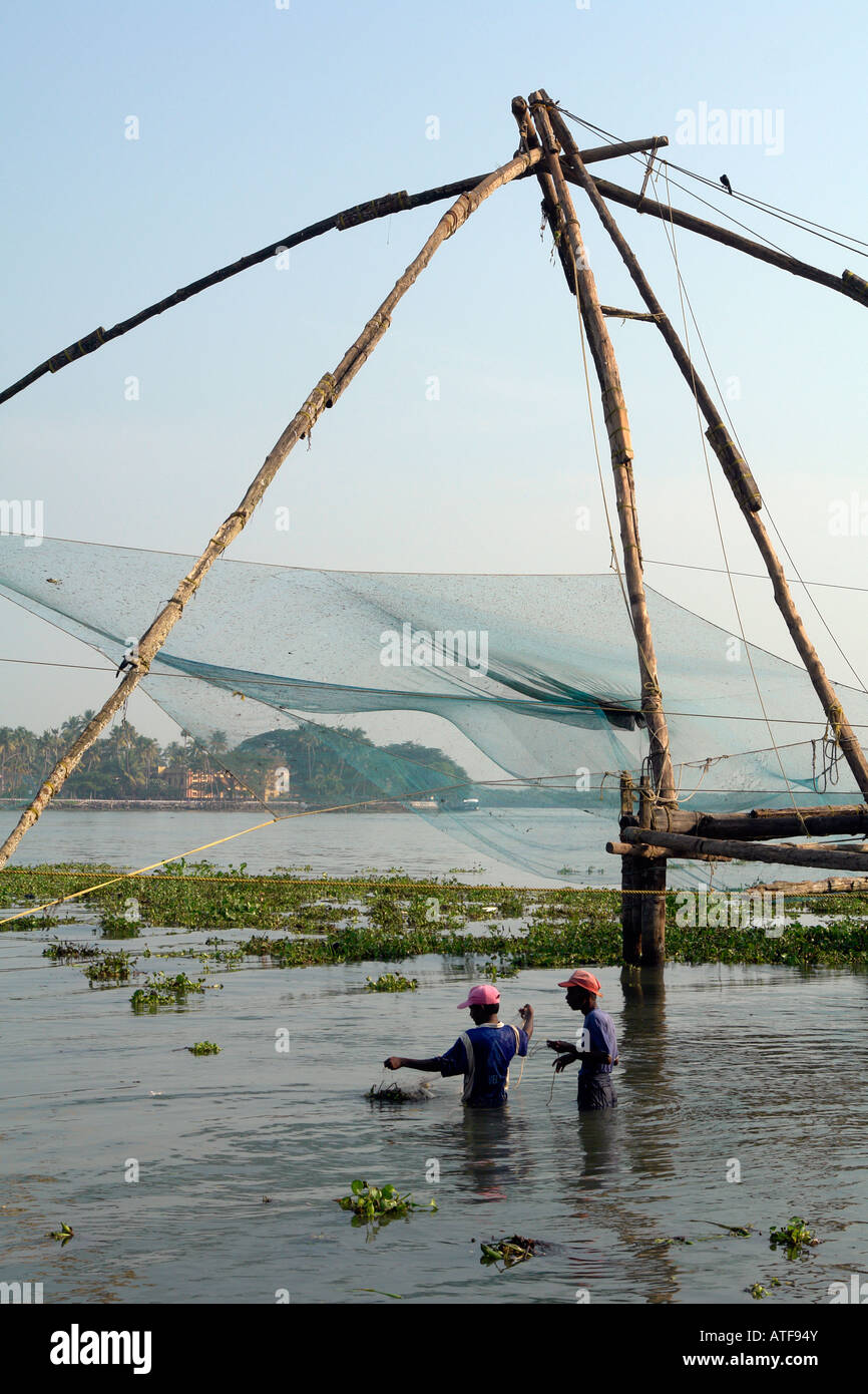 two indian fishermen with throw nets at the chinese fishing nets kochi ...