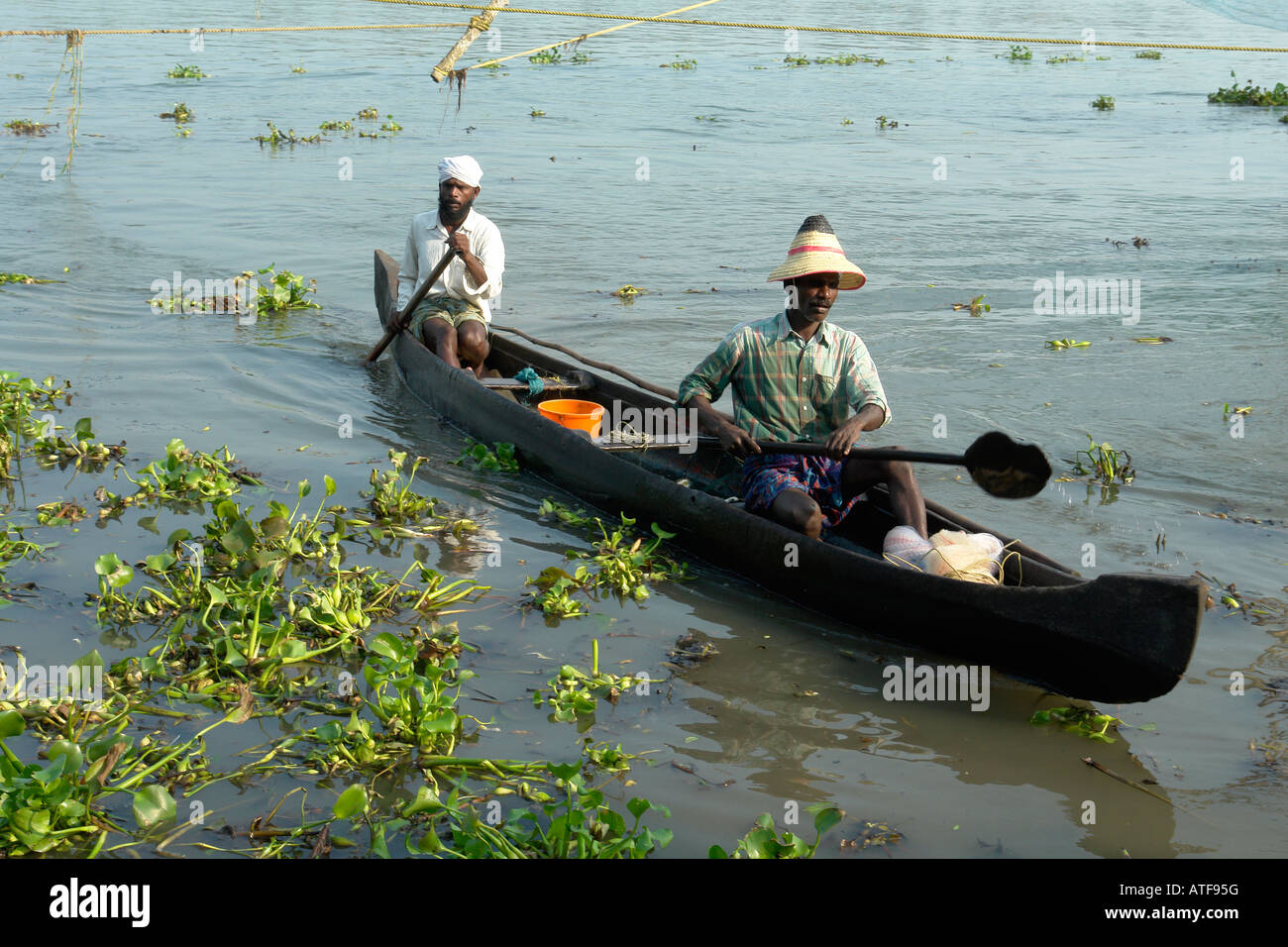 two indian fishermen with traditional fishing boat returning from a ...