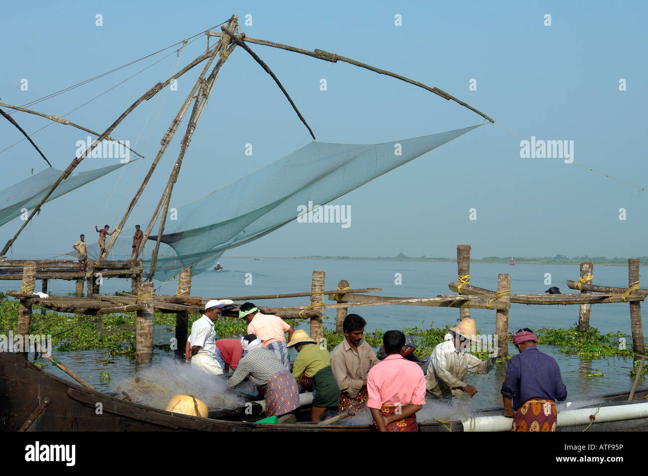indian fishermen repairing their nets at the chinese fishing nets in ...