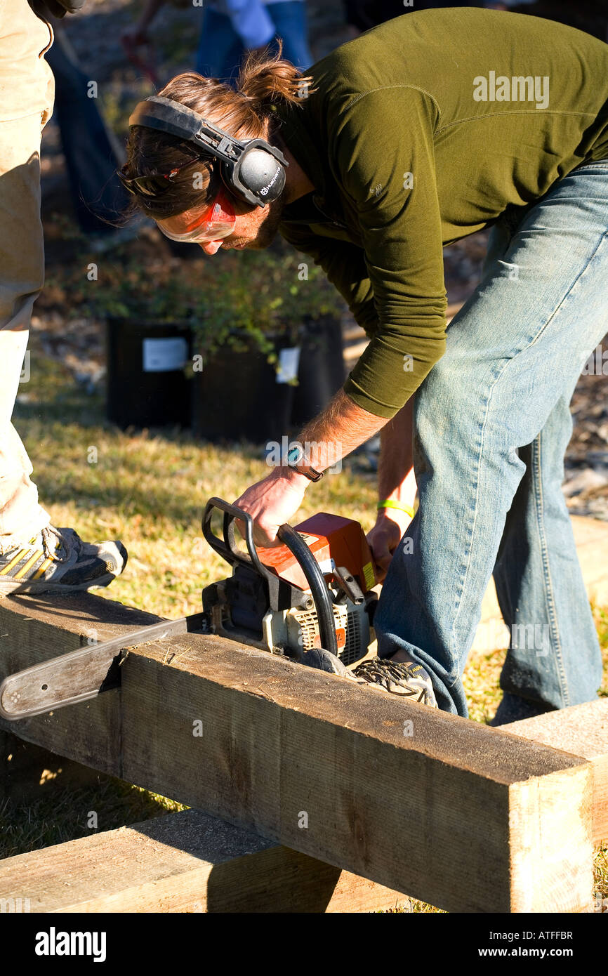 a young man saws wood Stock Photo - Alamy