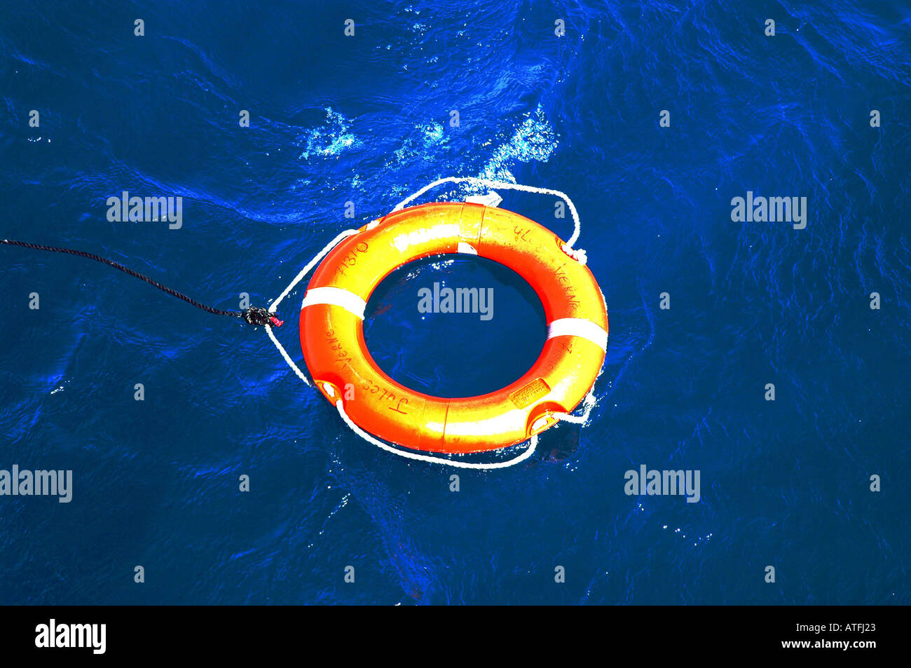 Orange life buoy with rope in the water Stock Photo - Alamy