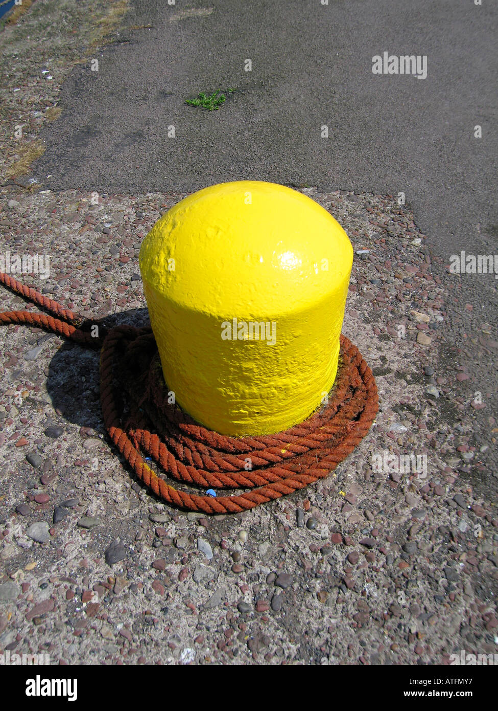 Bright yellow bollard on quayside Stock Photo - Alamy