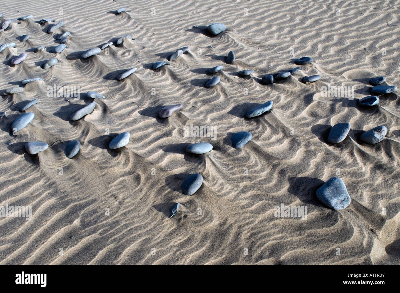 Stones in sand Stock Photo - Alamy