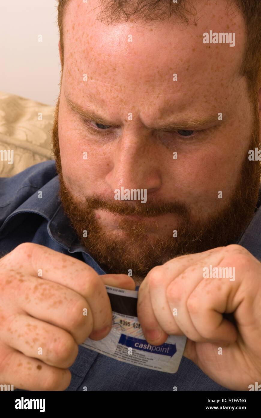 angry young man destroying credit debit bank card to avoid debt and ...