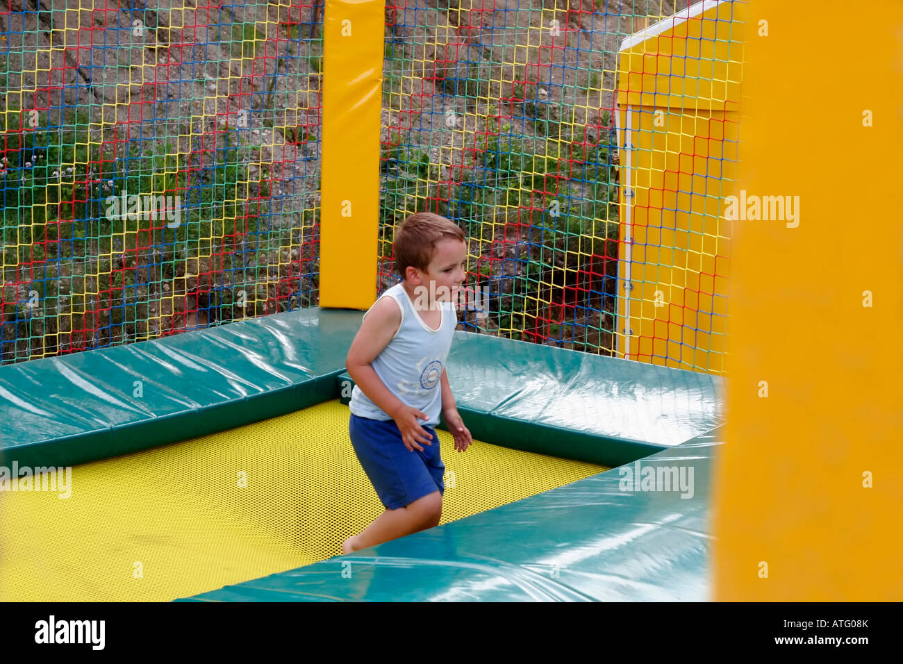 Young boy playing on bounce house at playground, A 6-year old boy ...