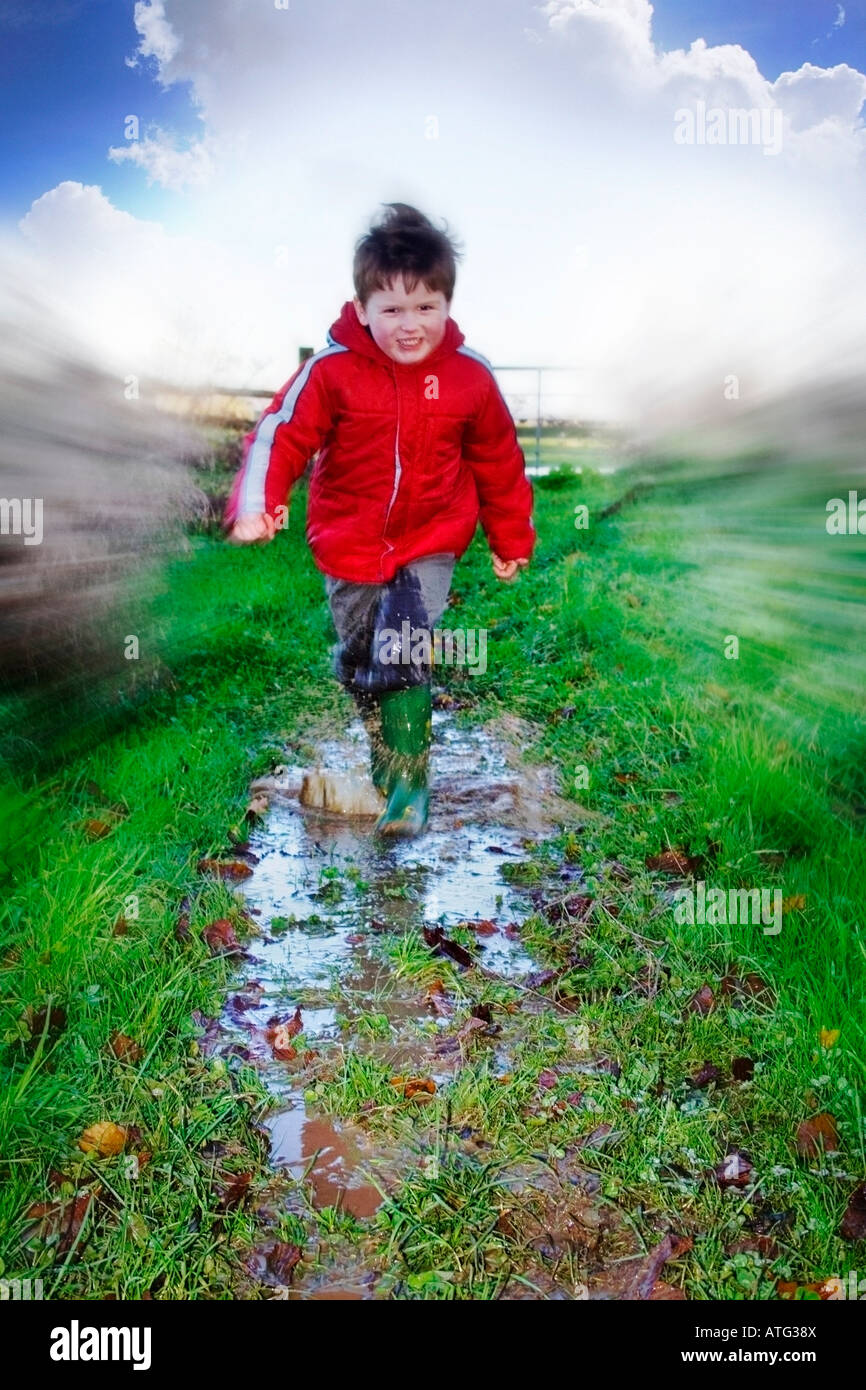 Boy running through muddy puddle Stock Photo - Alamy