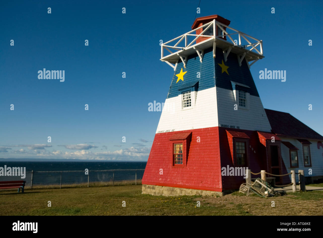 Stock image of a lighthouse in Acadian Colors at sunset with blue sky ...