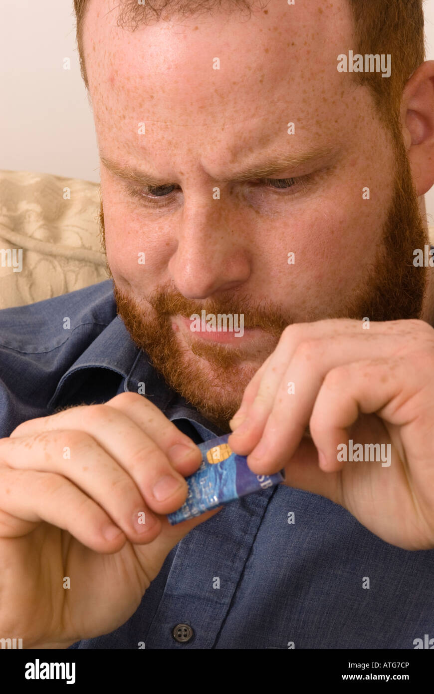 angry young man destroying credit debit bank card to avoid debt and ...