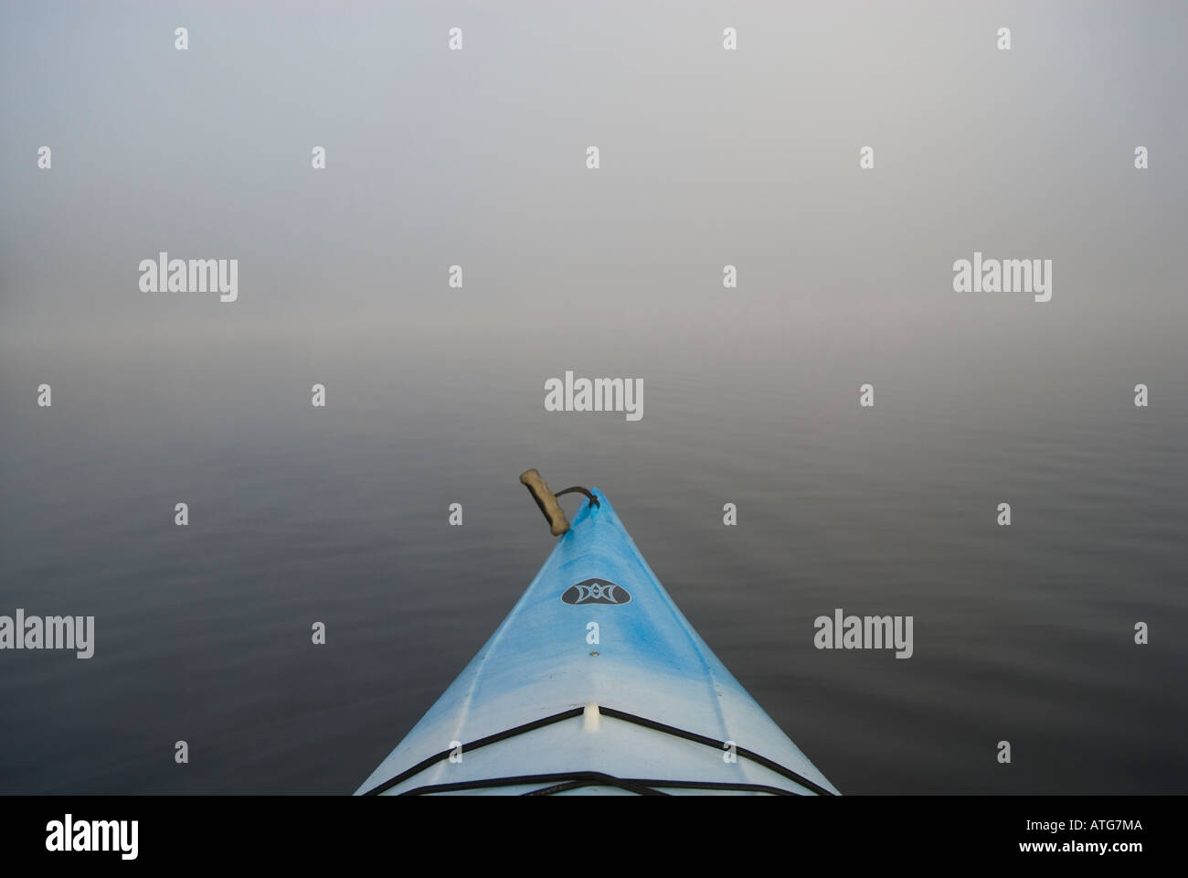 Stock image of kayak bow in the mist with sun breaking through the fog ...