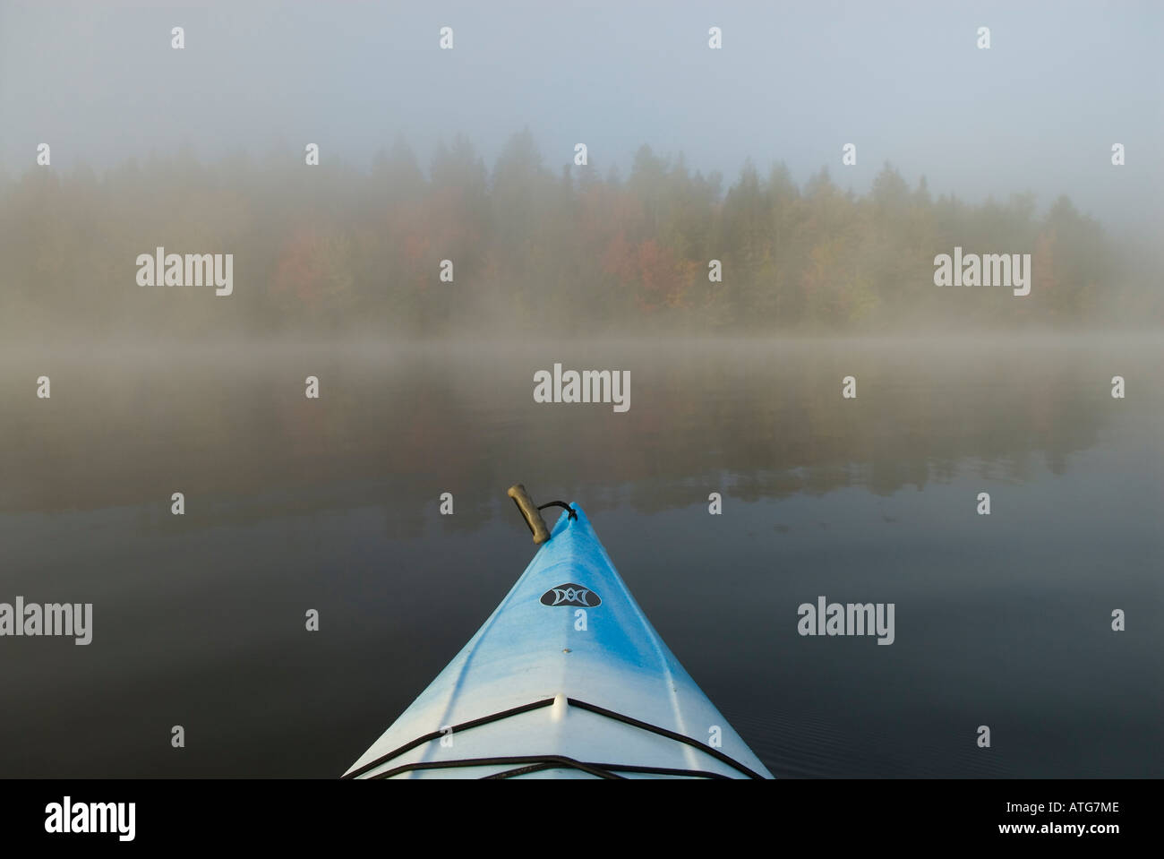 Stock image of kayak bow in the mist with sun breaking through the fog ...