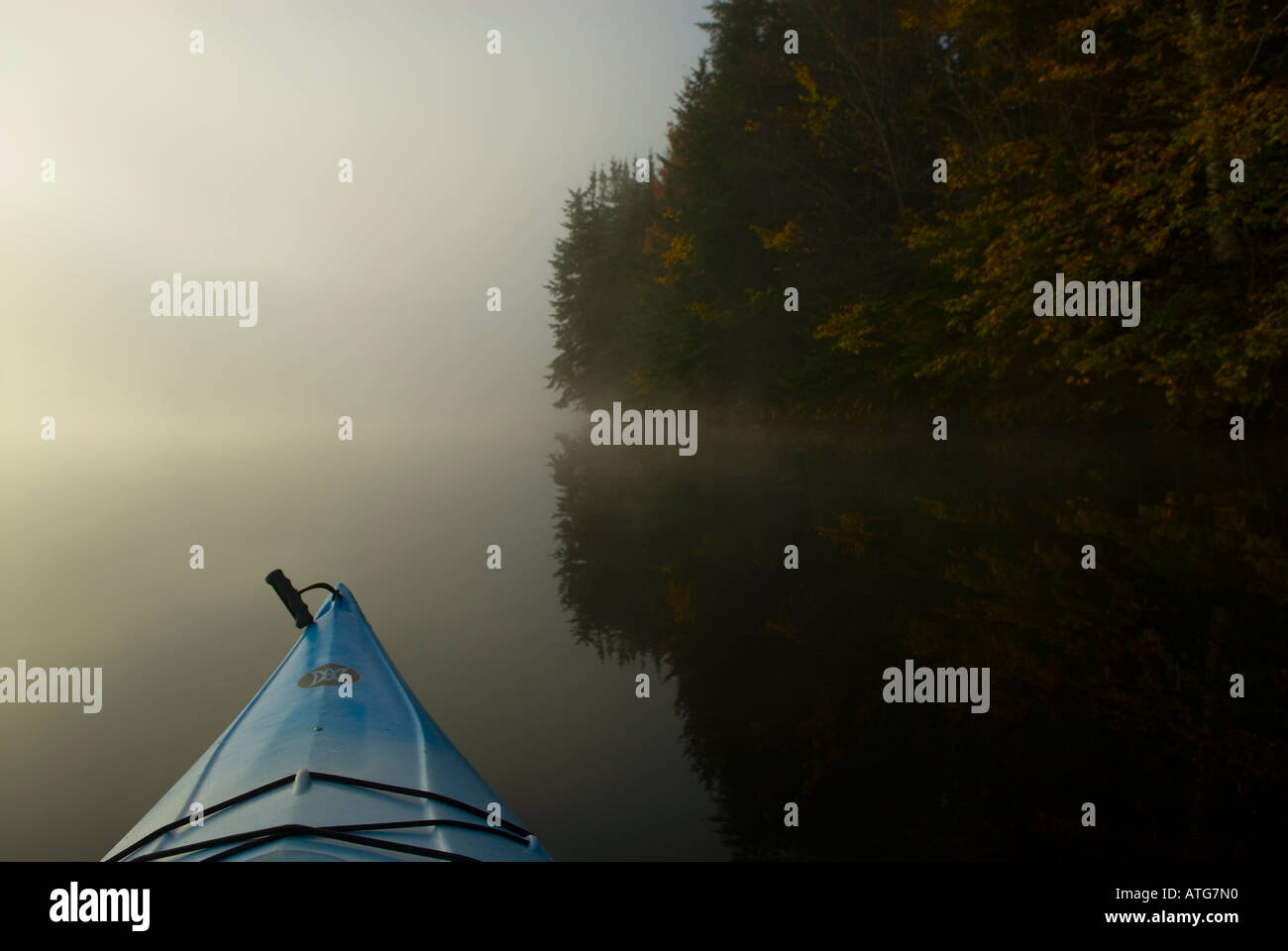 Stock image of kayak bow in the mist with sun breaking through the fog ...