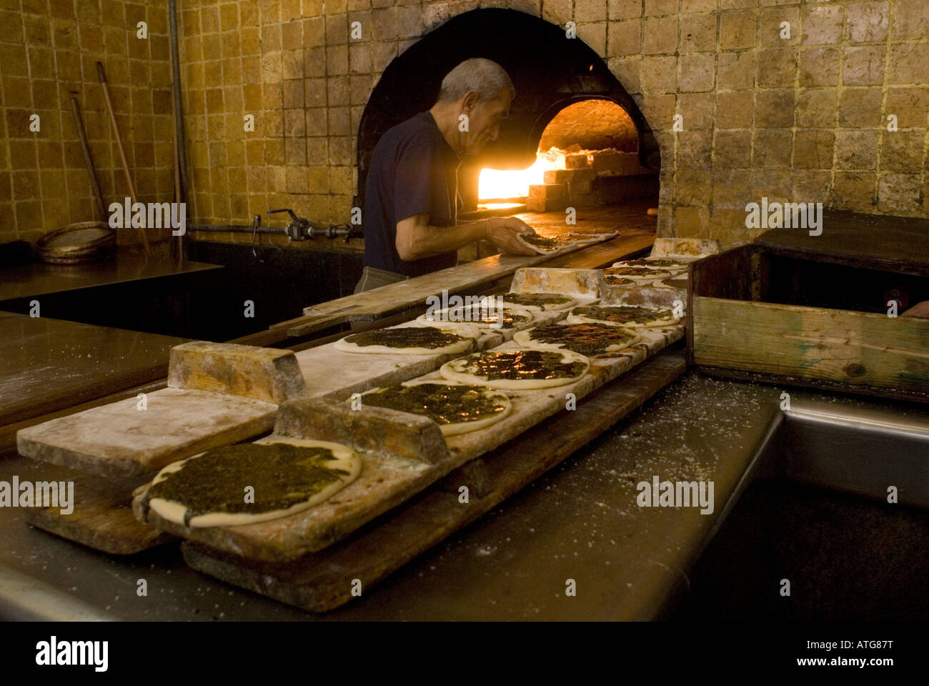 An Israeli Arab man placing traditional Manakish za'atar bread inside a ...
