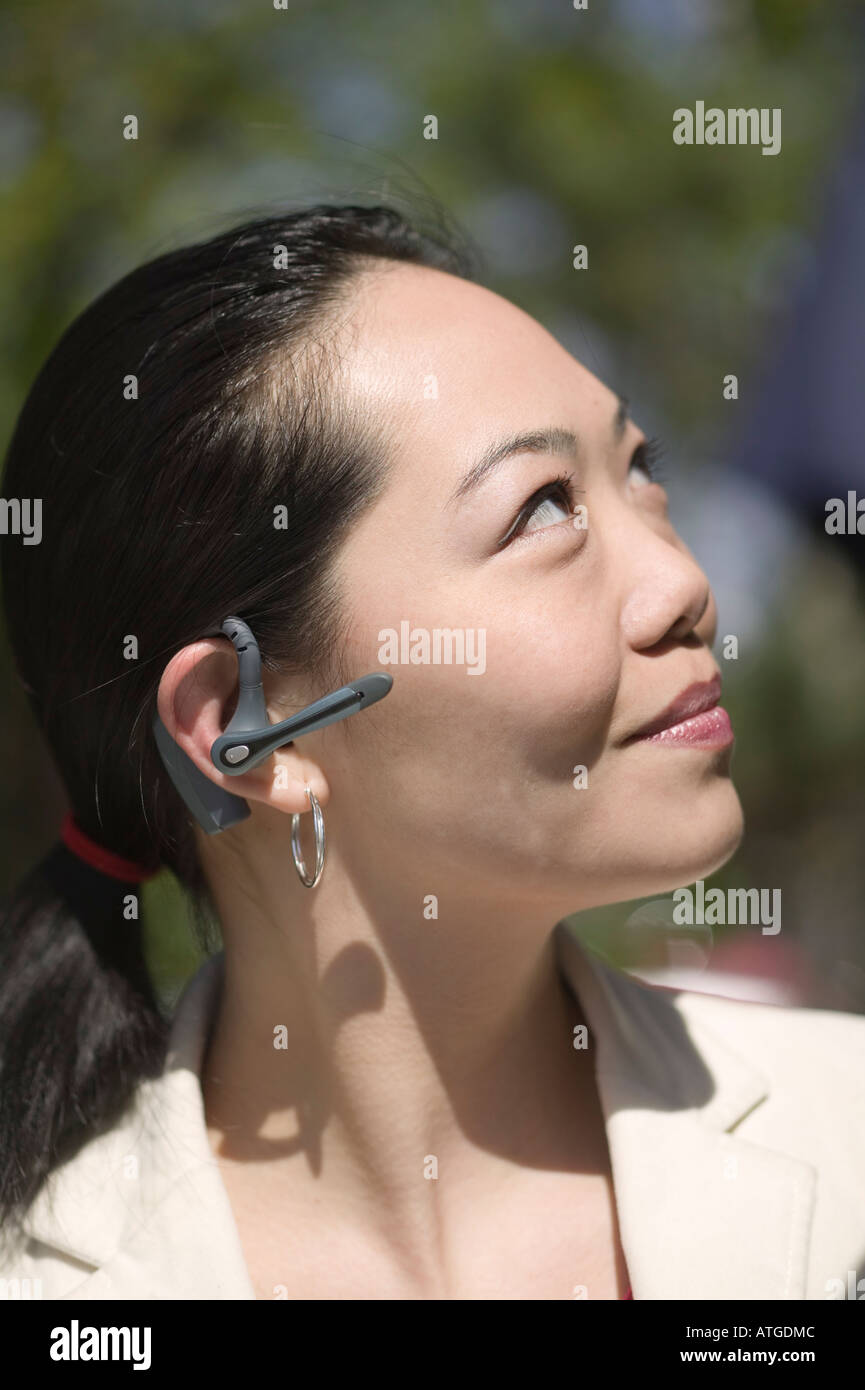 Asian Woman Wearing a Bluetooth Headset Stock Photo - Alamy