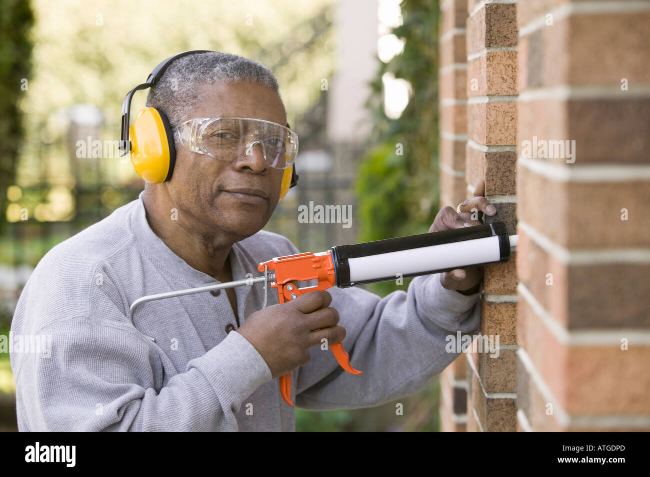 African American Man Using a Caulking Gun Stock Photo - Alamy