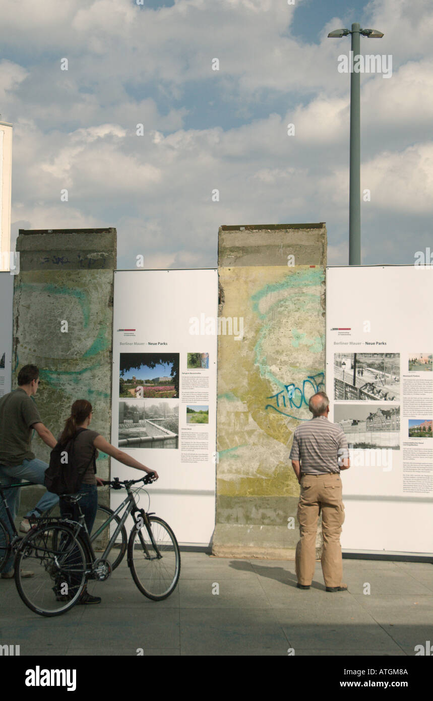 People studying the pictoresque description fitted to the Berlin Wall ...