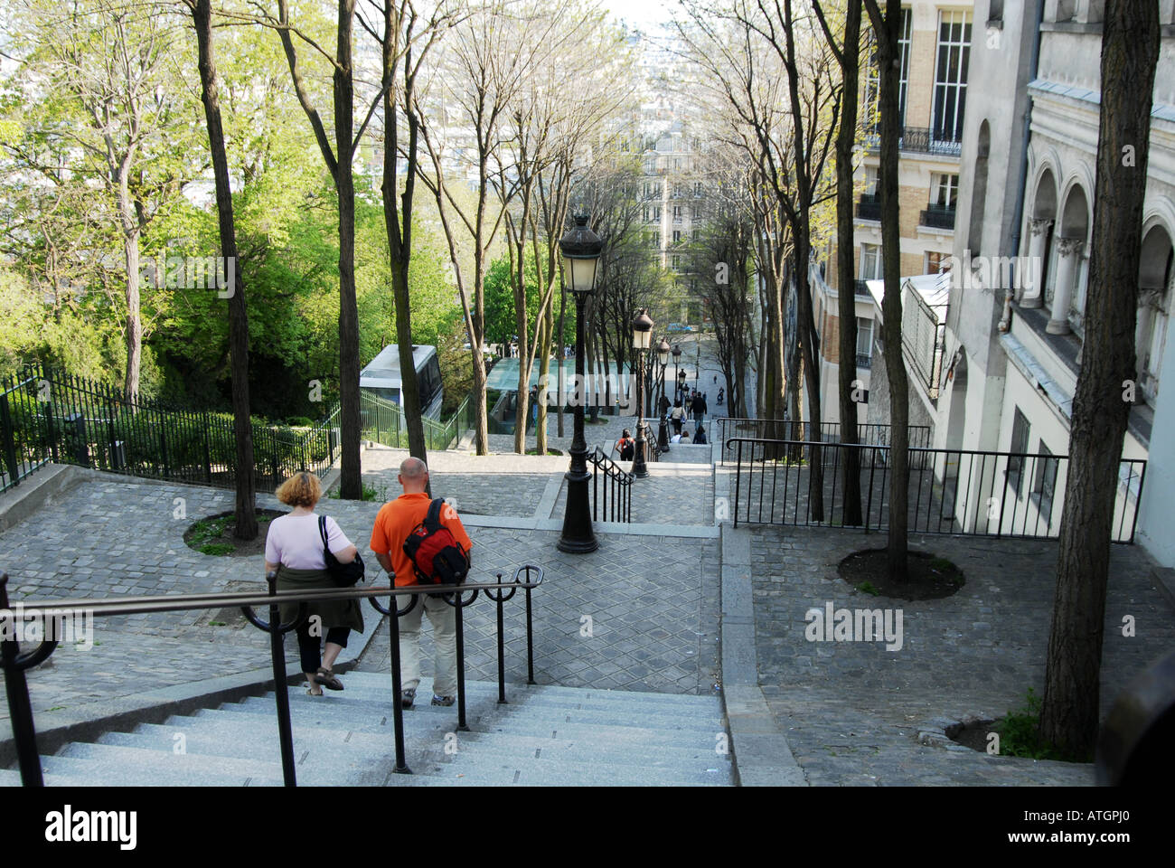 Woman and man walking down steep steps in the Montmartre section of ...