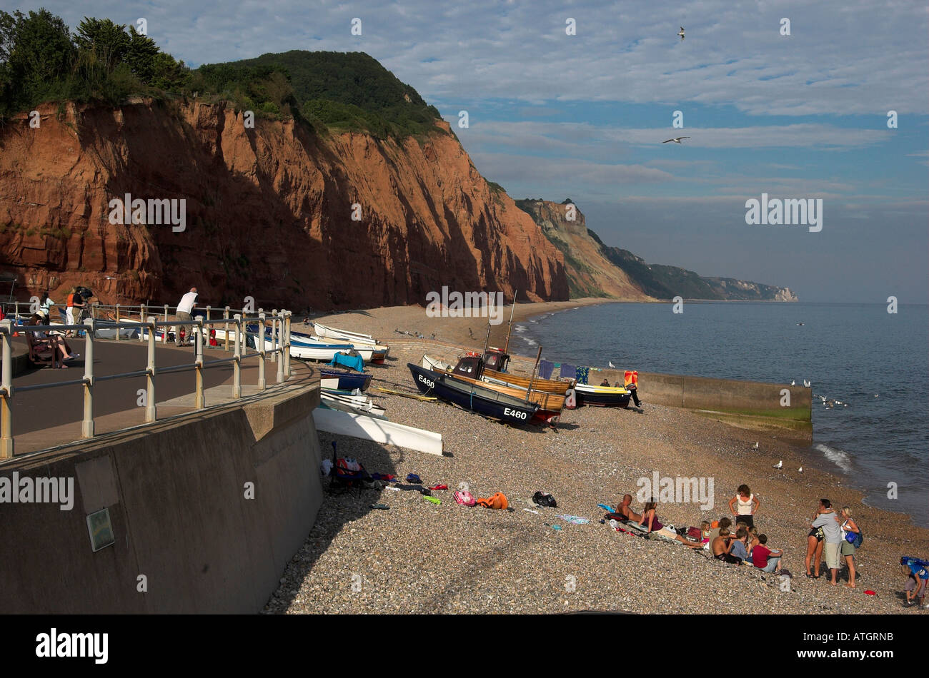 Summer evening sunshine, promenade, beach and red sandstone cliffs ...