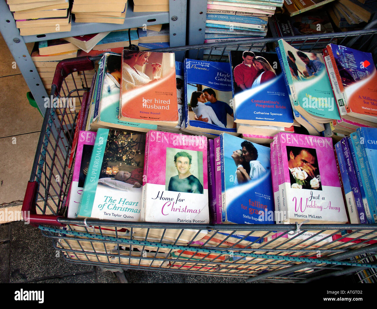 Shopping cart filled with romance novel books Stock Photo - Alamy