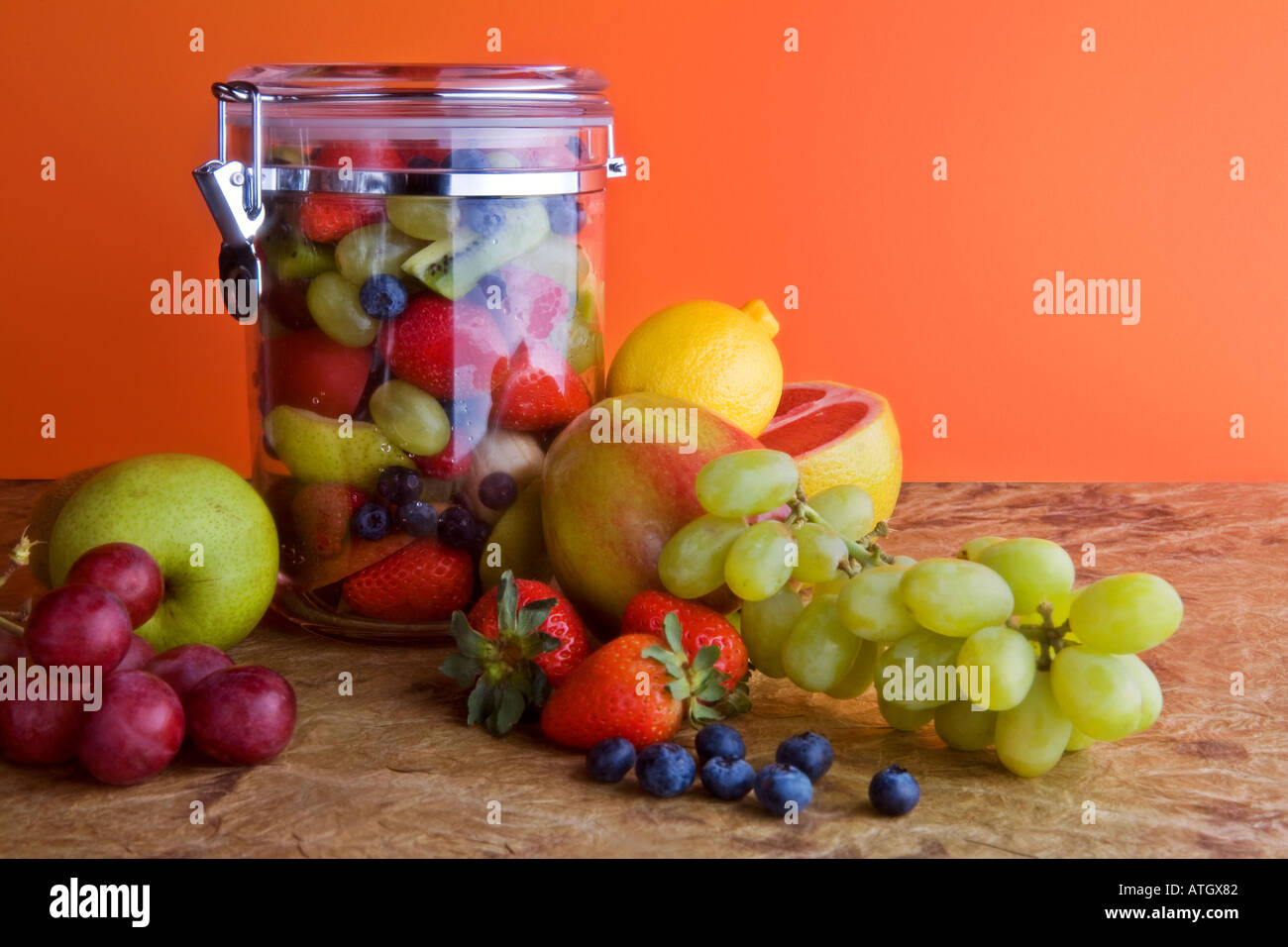 Still Life, assorted fruits in a jar and on a table with orange ...