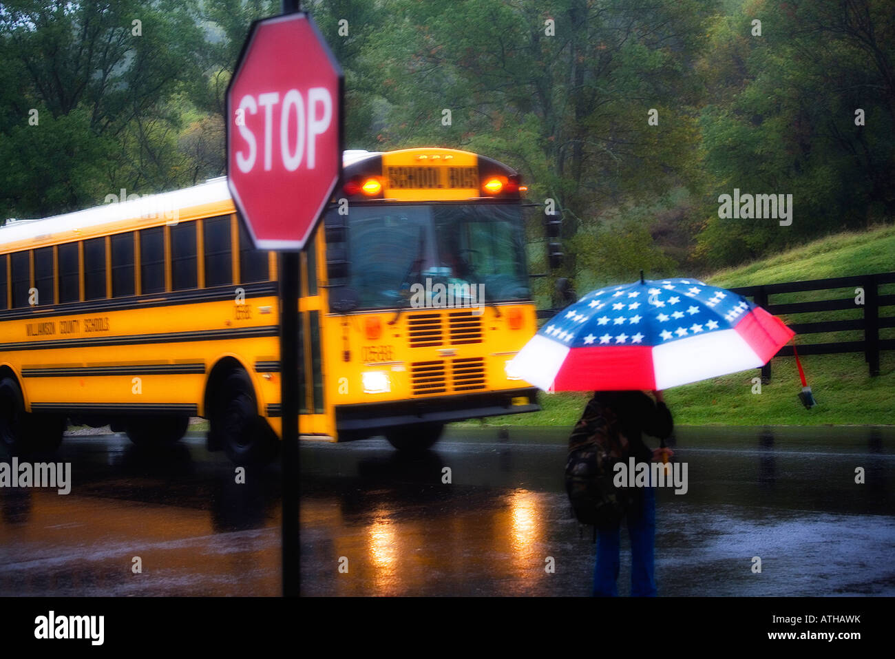 Young boy waiting for school bus in the rain Stock Photo - Alamy