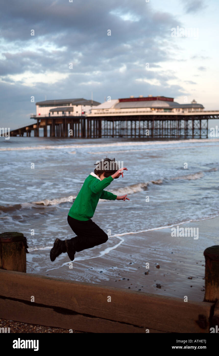 Boy jumps from boardwalk on beach Stock Photo - Alamy
