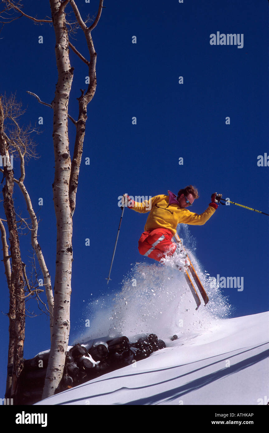 a skier jumps snow covered logs on a cloudless day Stock Photo - Alamy