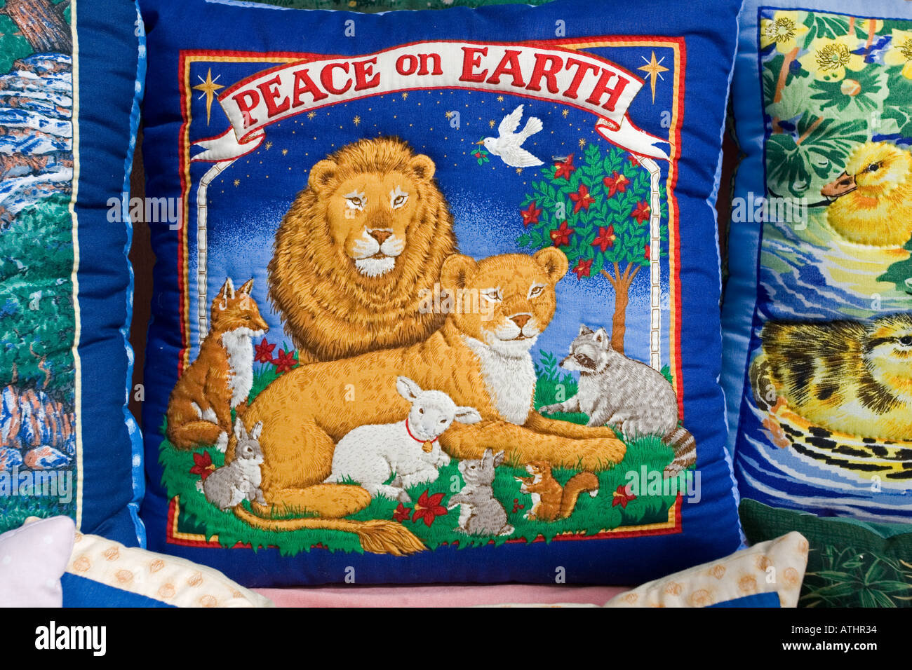 Colourful cushion with lion and lamb headed Peace on Earth on stall at ...