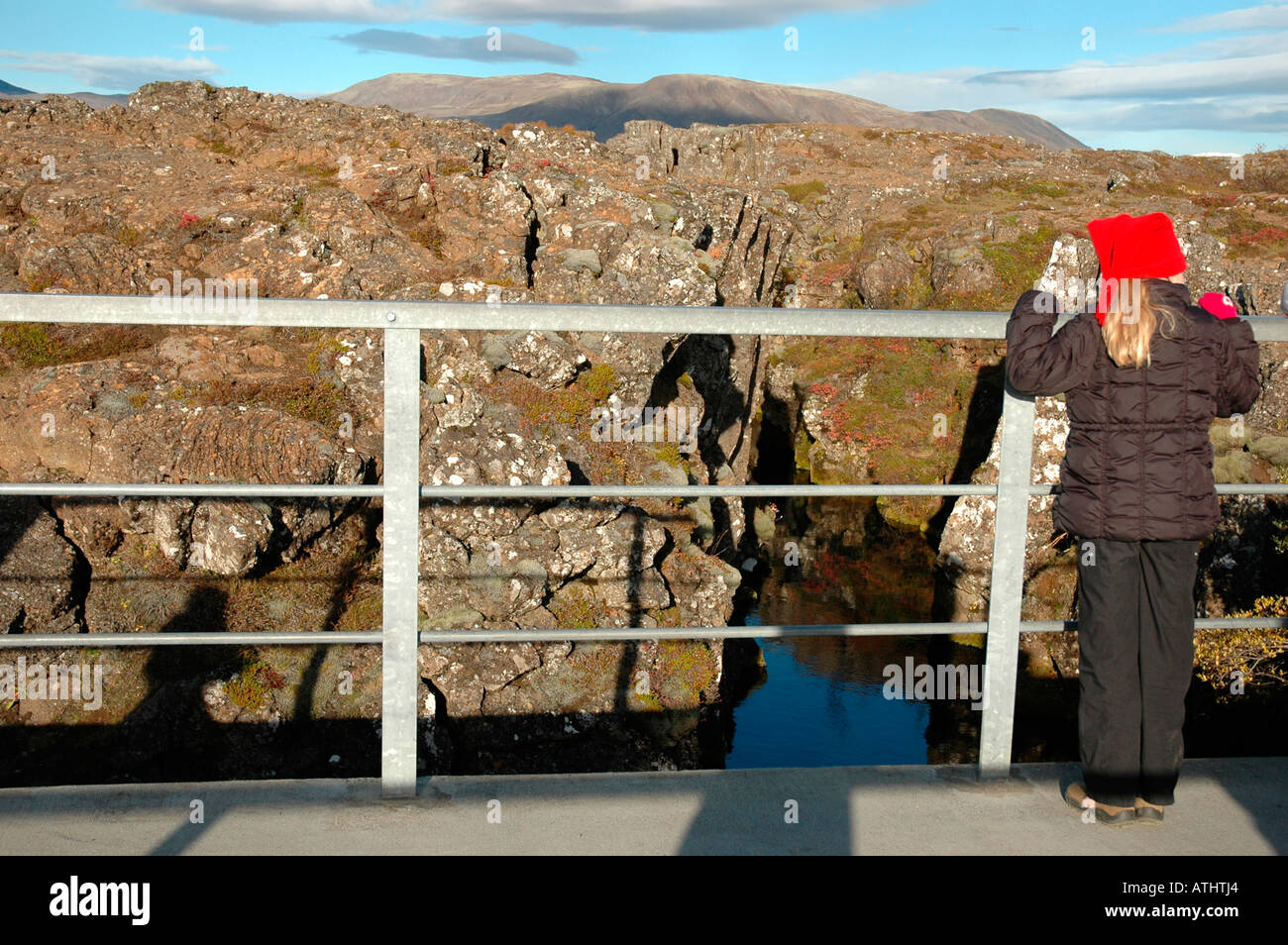Young girl looking into Mid Atlantic Rift in Thingvellir National Park ...