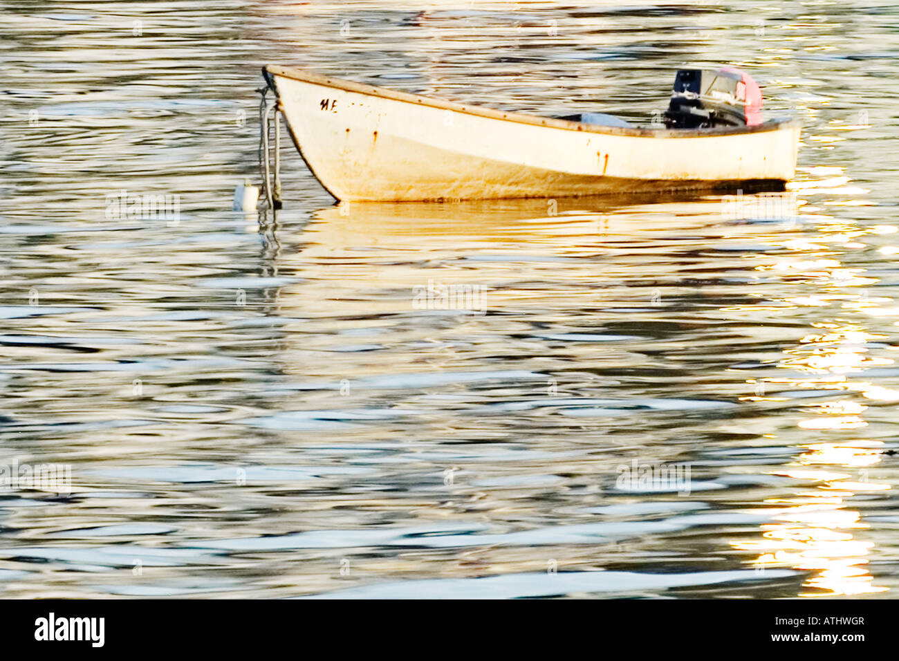 Small white boat with motor anchored in a harbor Stock Photo - Alamy