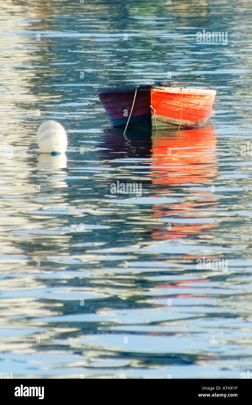 Photo of a red boat anchored in a bay Stock Photo - Alamy