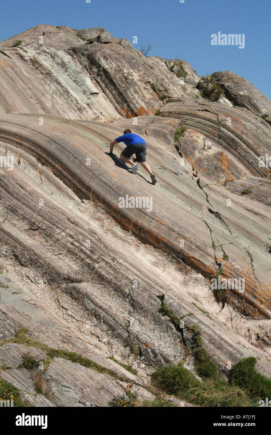 American man sliding down the natural rock slides at the Sacsayhuaman ...