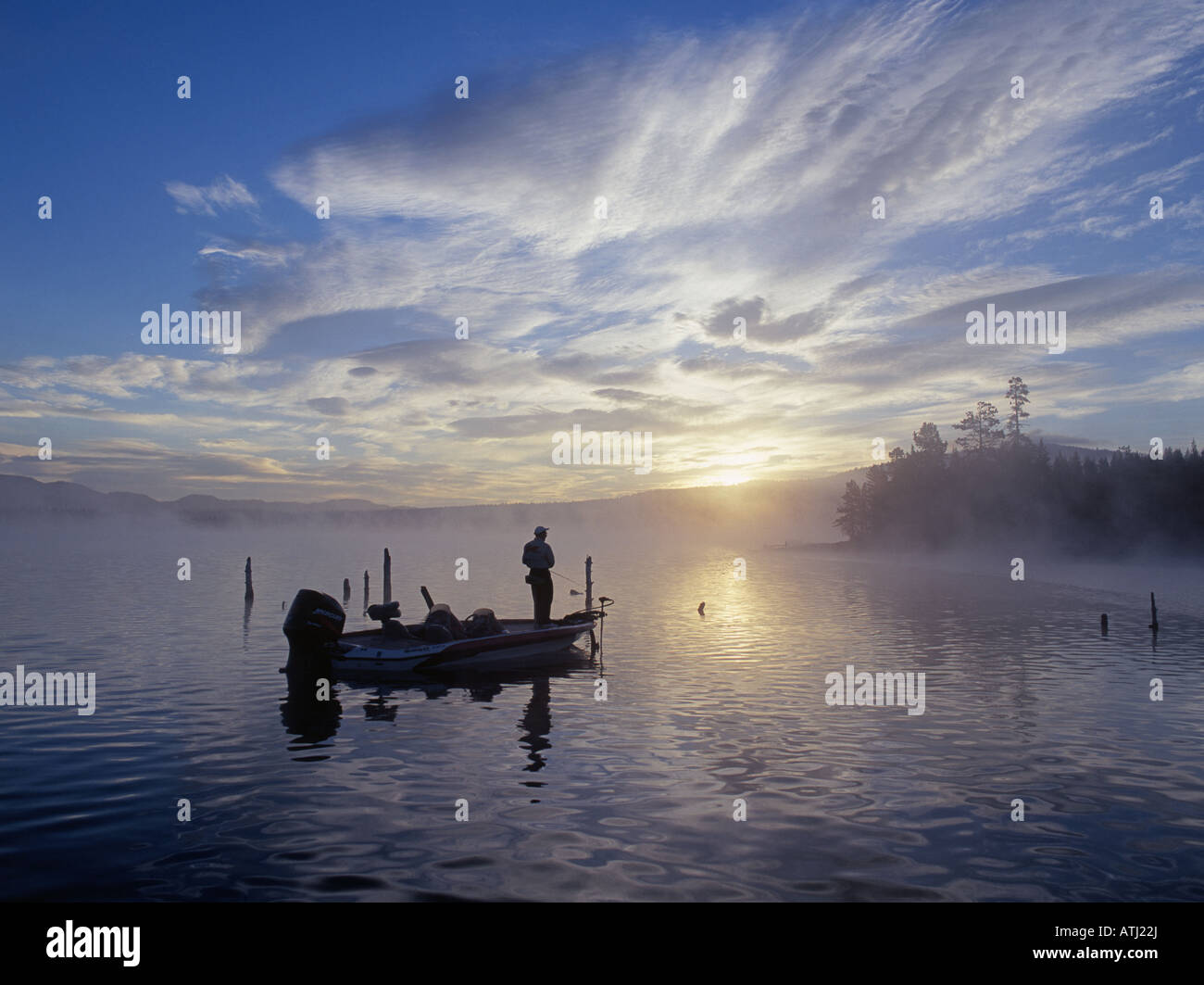 A bass fisherman fishes for largemouth bass at dawn on a foggy Crane ...
