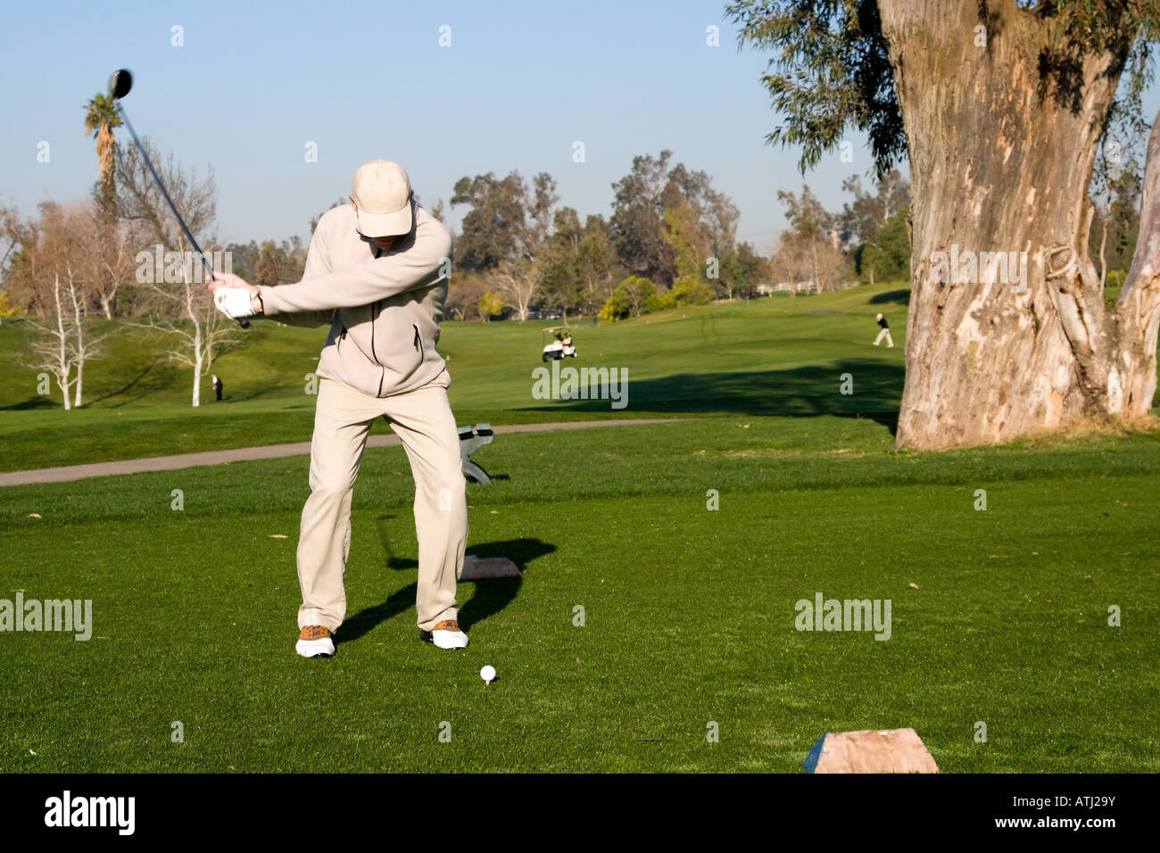 Golfers and a resort golf course in action Stock Photo - Alamy