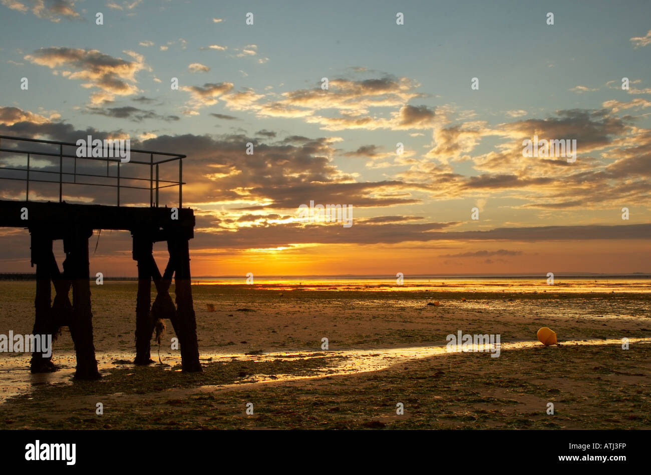 Sunset silhouette of a pier or jetty on a beach Stock Photo - Alamy
