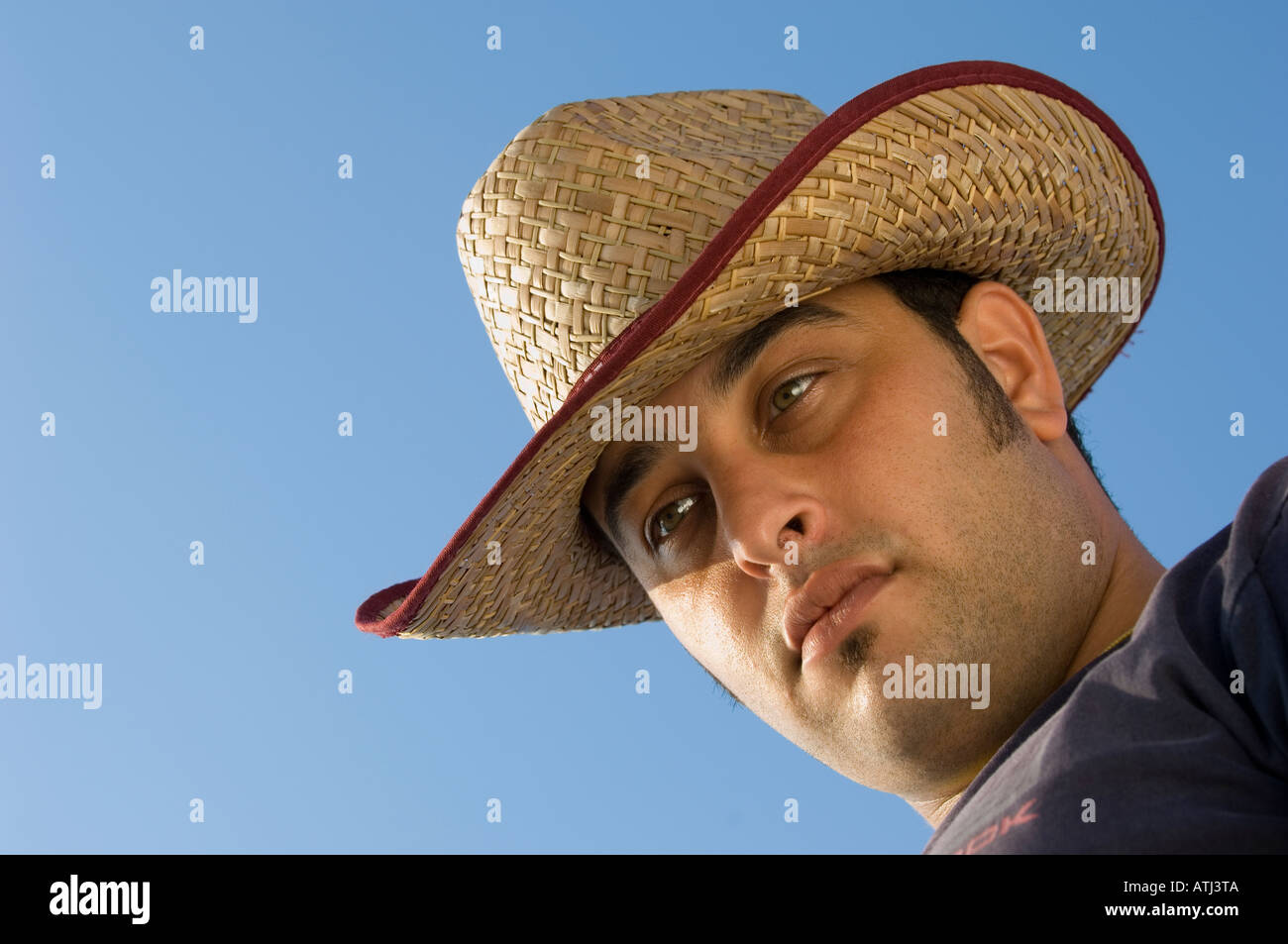 Man wearing straw hat looking down Stock Photo - Alamy