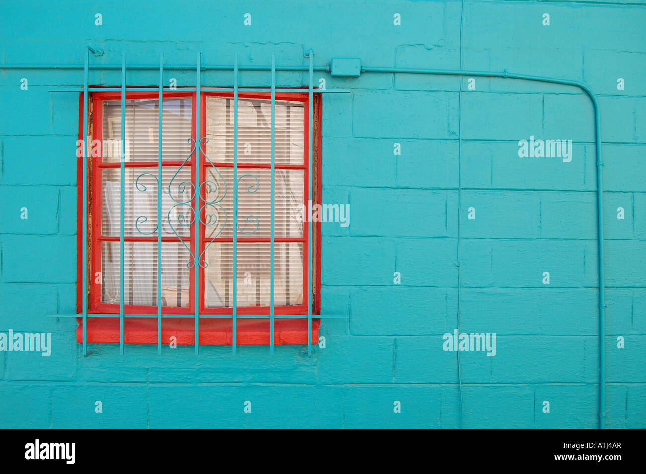 Blue/green wall with a red framed window Stock Photo - Alamy