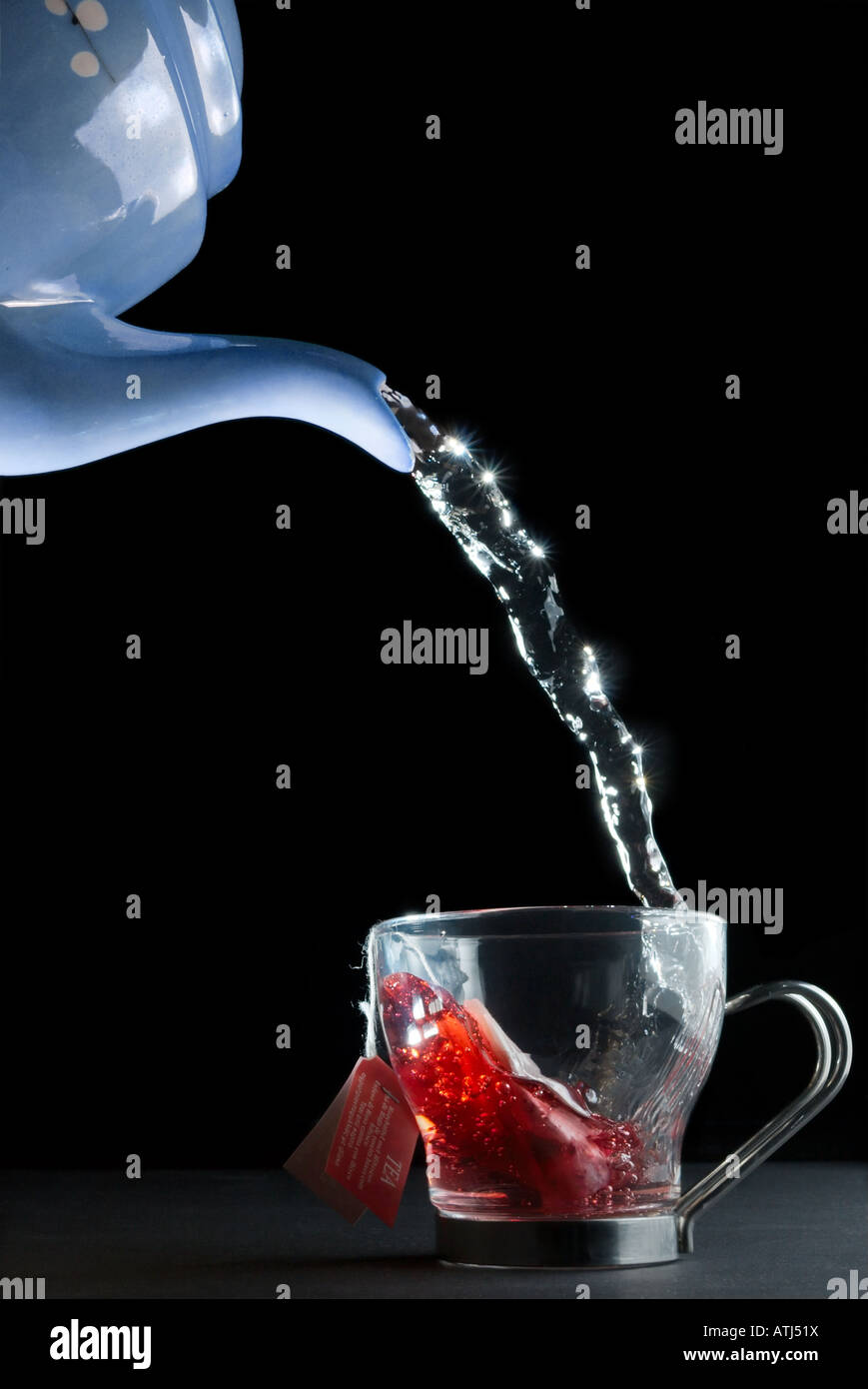 Hot water being poured into a cup with a teabag in it Stock Photo - Alamy