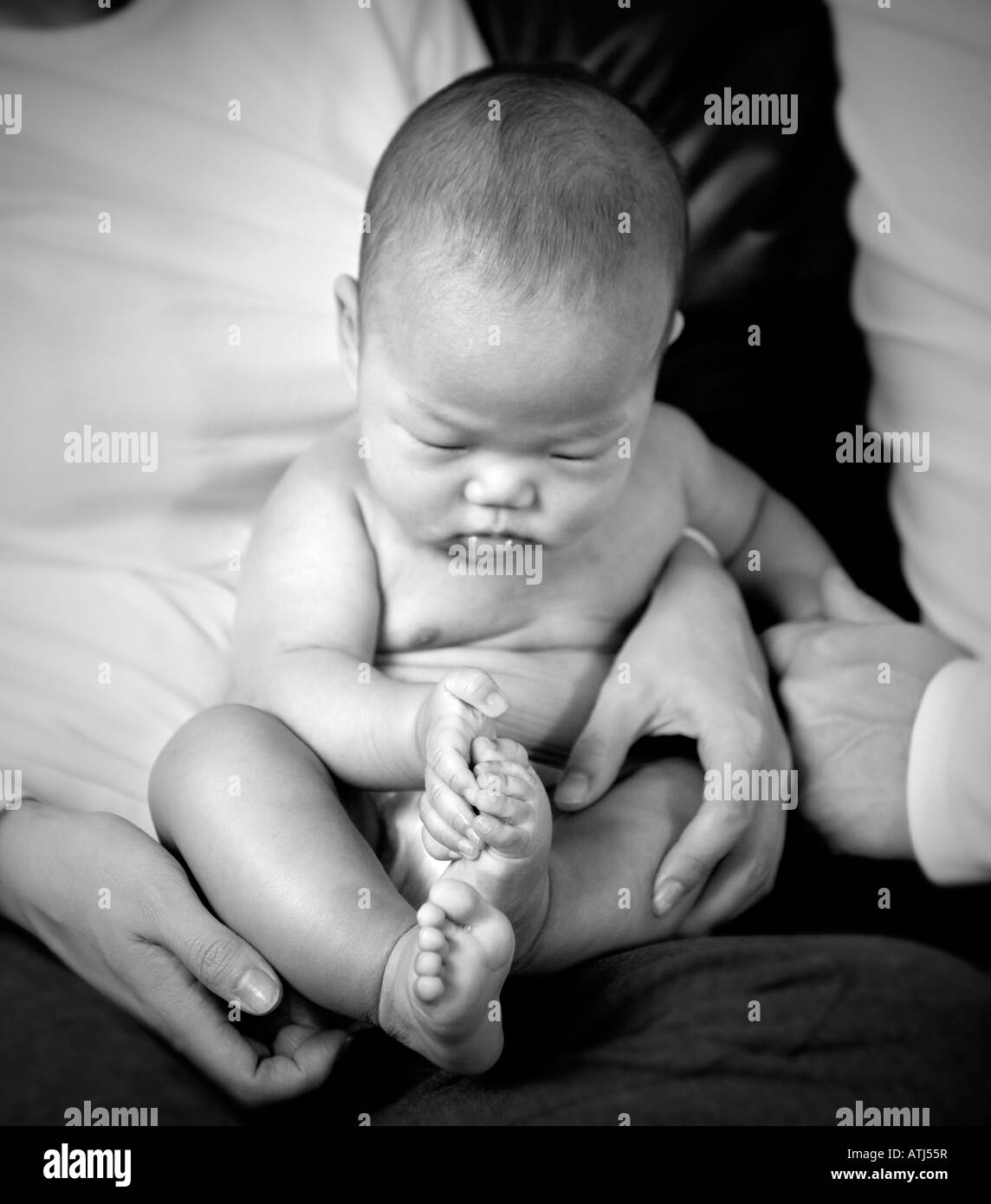 Asian baby feeling feet Stock Photo - Alamy