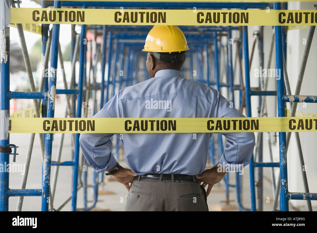 Rear view of a male architect standing at a construction site Stock ...