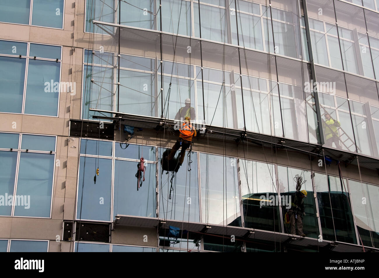 workmen working on side of large building, london uk Stock Photo - Alamy