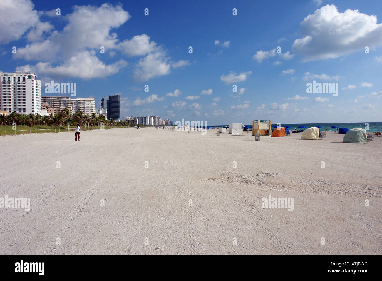 Tire tracks on sand with tents in distance at beach at Miami Beach ...