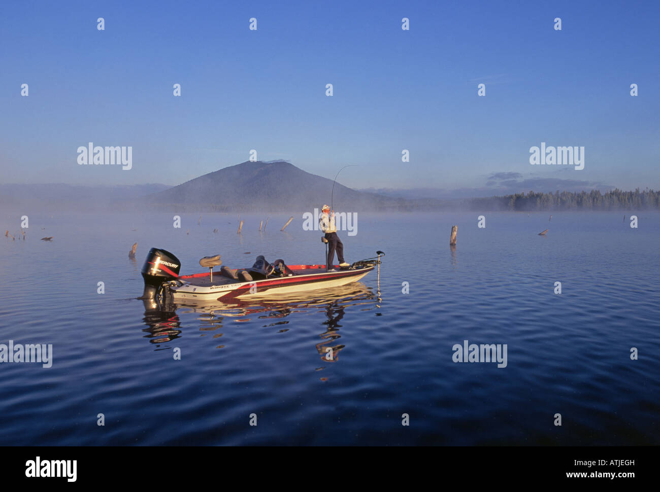 A largemouth bass fisherman on Crane Prairie Reservoir on a foggy ...