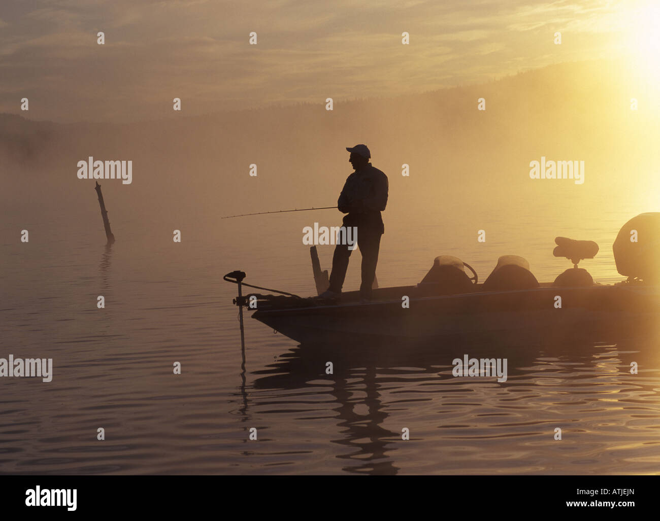 A largemouth bass fisherman on Crane Prairie Reservoir on a foggy ...