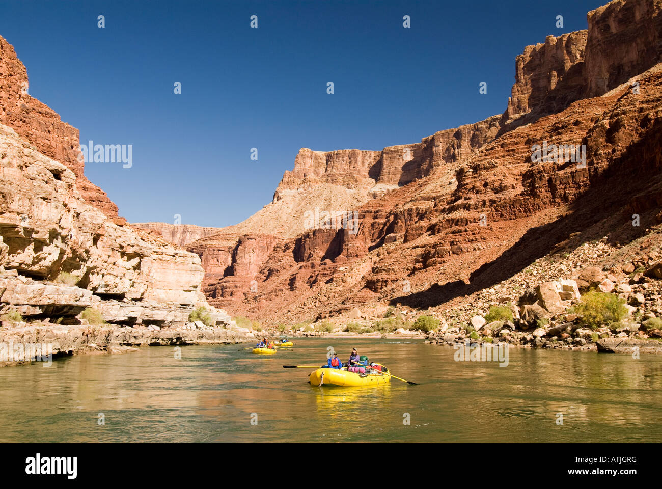 Female guide looks up to rim while rafting the Colorado River in the ...