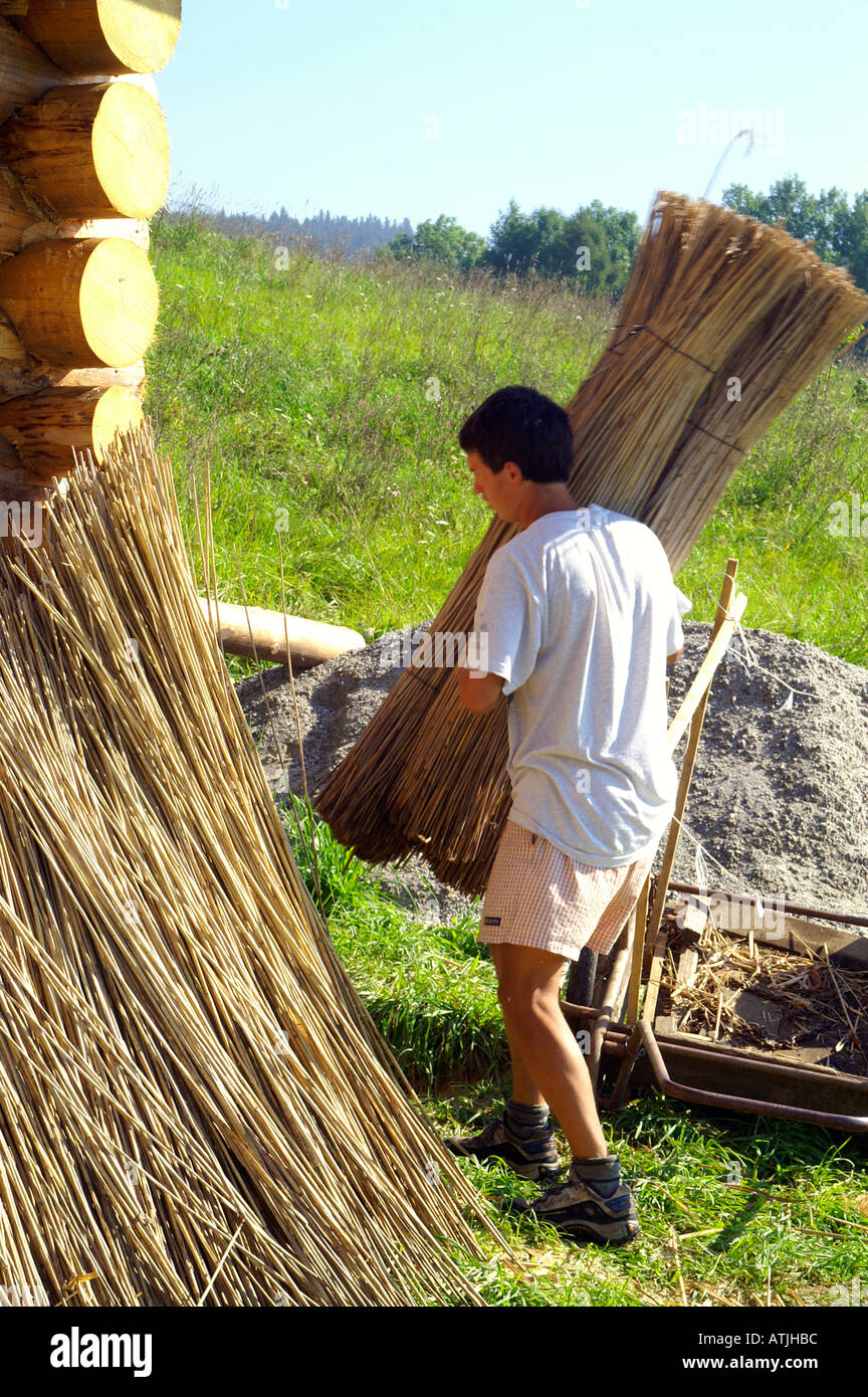 Man carrying straw bolts used for straw roof of slovak traditional ...