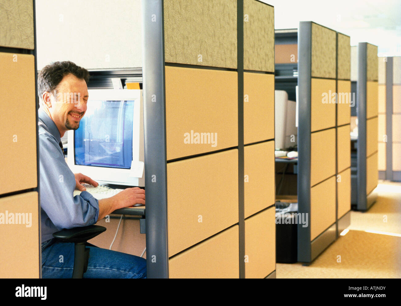 A businessman looking out of his office cubicle while typing on a keyboard Stock Photo - Alamy